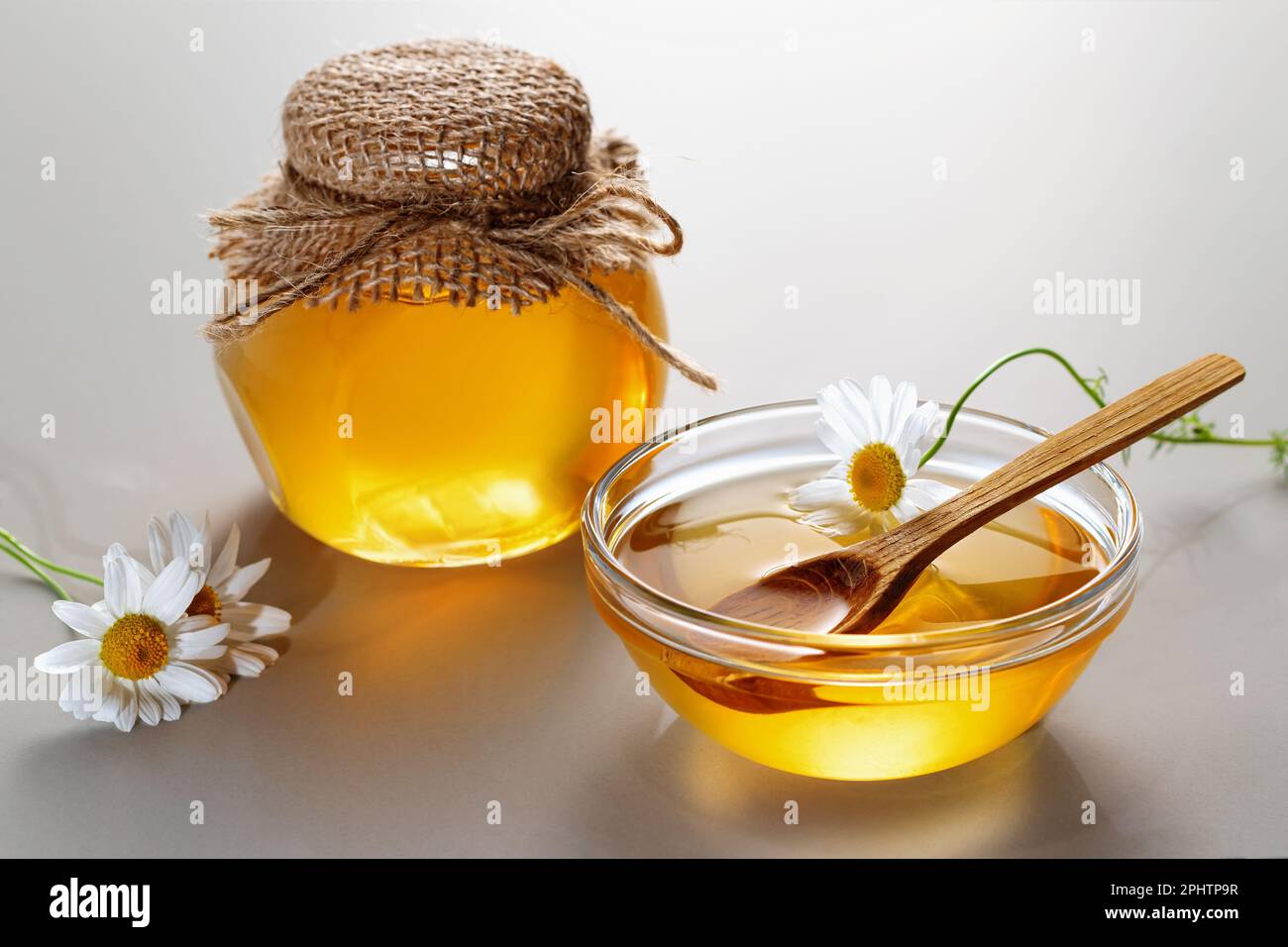 Chamomile syrup in a small bowl and jar on the kitchen table Stock ...