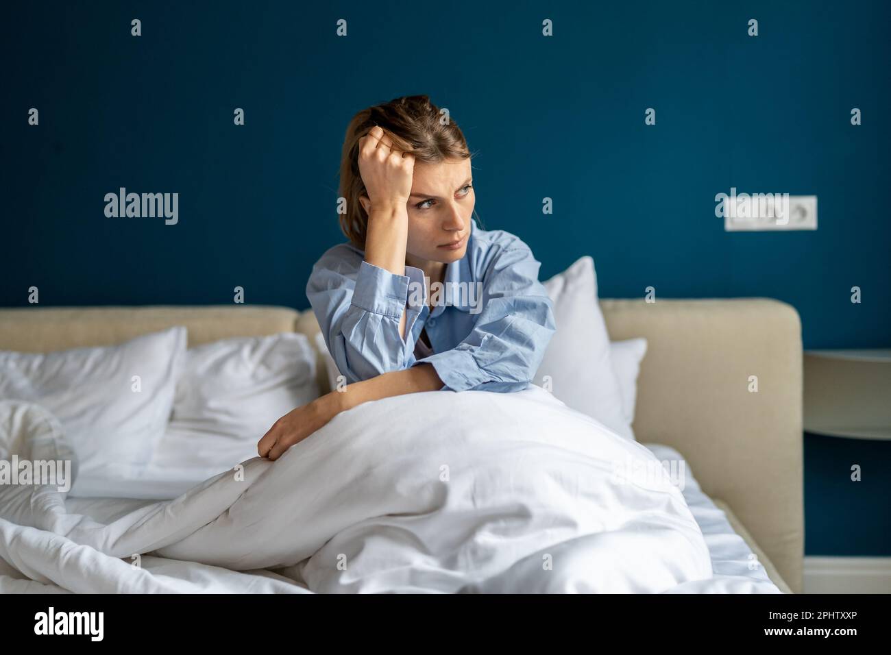 Stressed woman sit on bed with morning bad mood, touch head, suffer ...