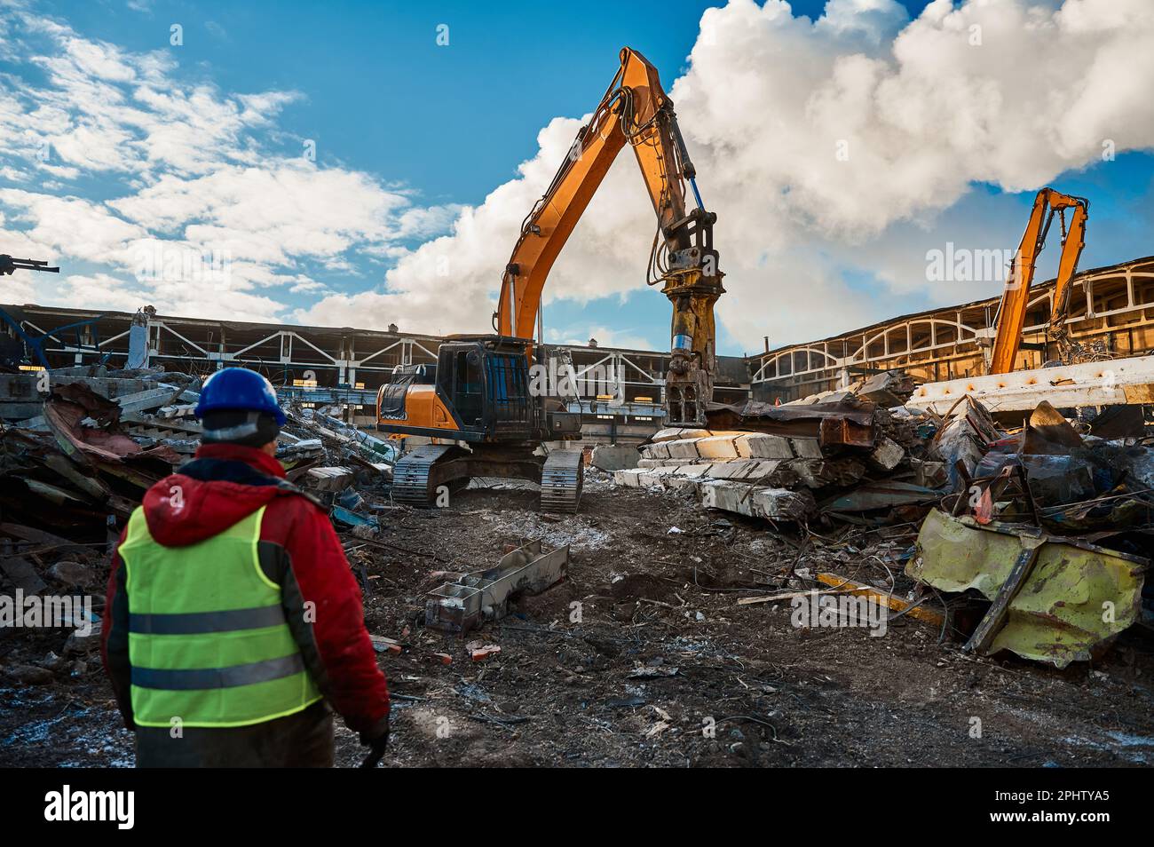 Excavator destroyer removes debris under worker control Stock Photo - Alamy