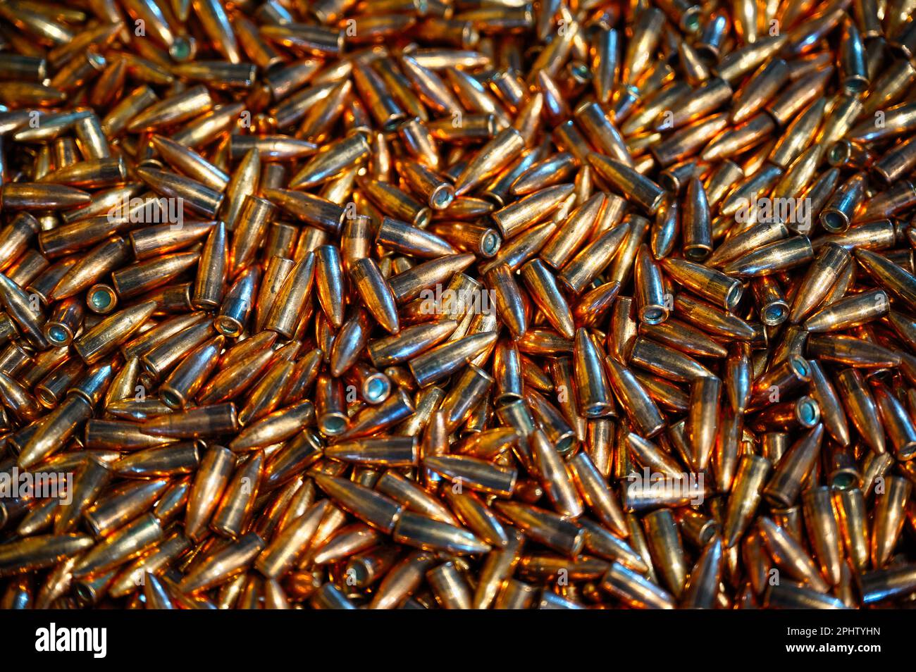 Glowing large caliber bullet heap for riffle as background Stock Photo ...
