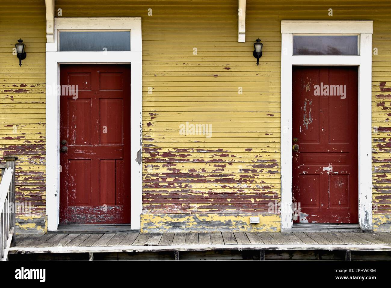 Antique yellow house duplex red doors Stock Photo - Alamy