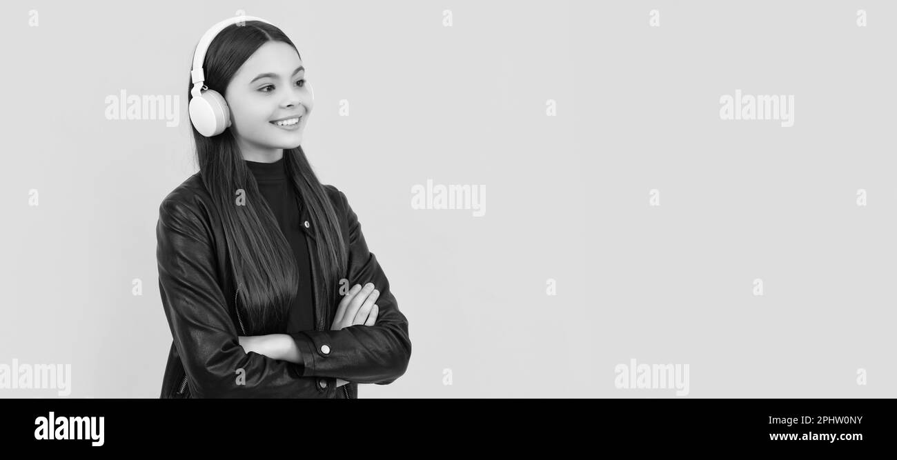 cheerful teen girl listen music in headphones on yellow background ...
