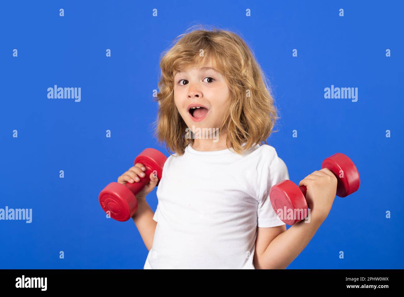 Child boy pumping up biceps muscles with dumbbell. Fitness kids with ...