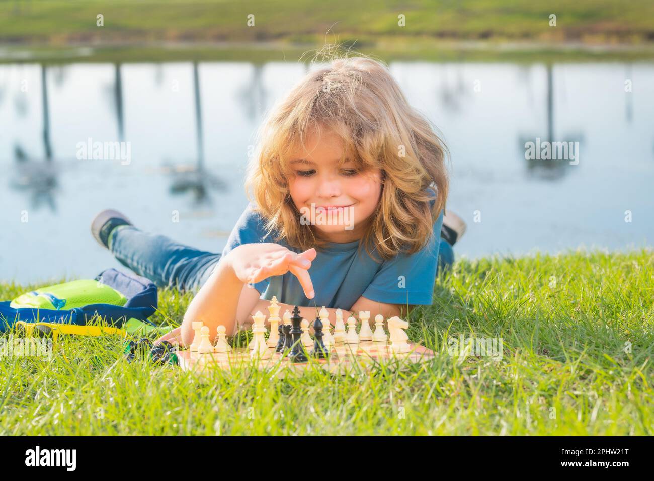 Little child play chess. Kid playing board game. Thinking child ...