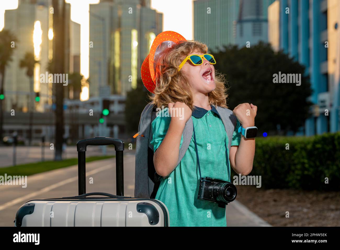 Portrait of happy child traveler with luggage. Positive little tourist ...