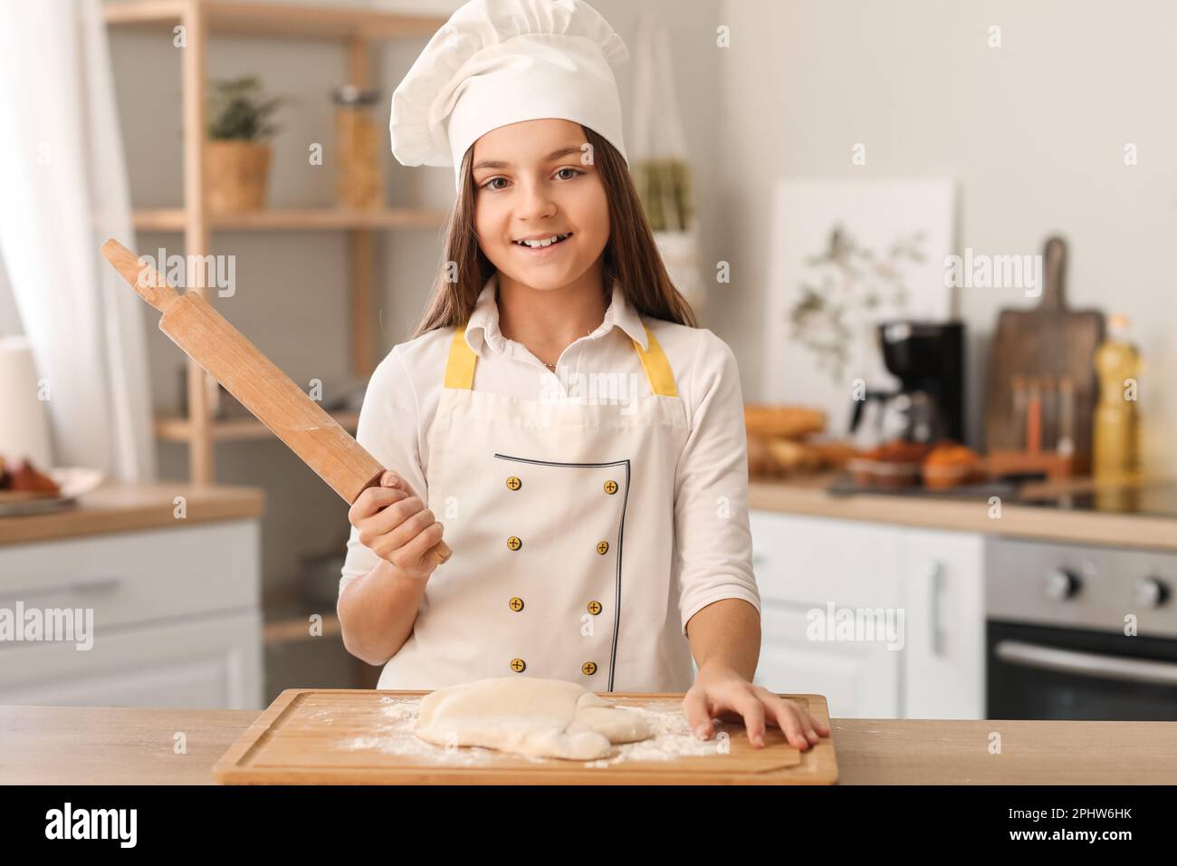 Little baker with rolling pin and dough at table in kitchen Stock Photo ...