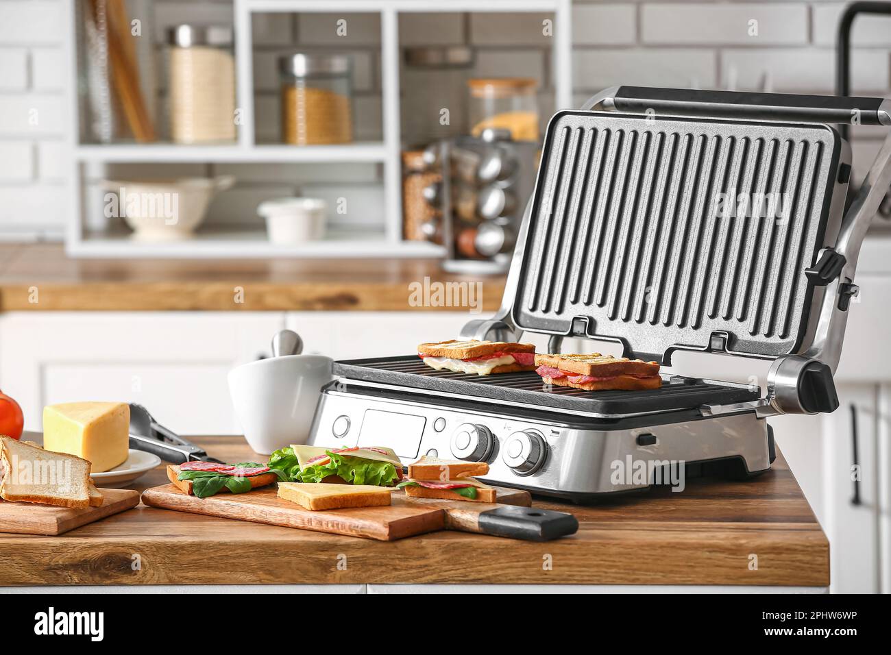 Modern electric grill with sandwiches on kitchen counter Stock Photo ...