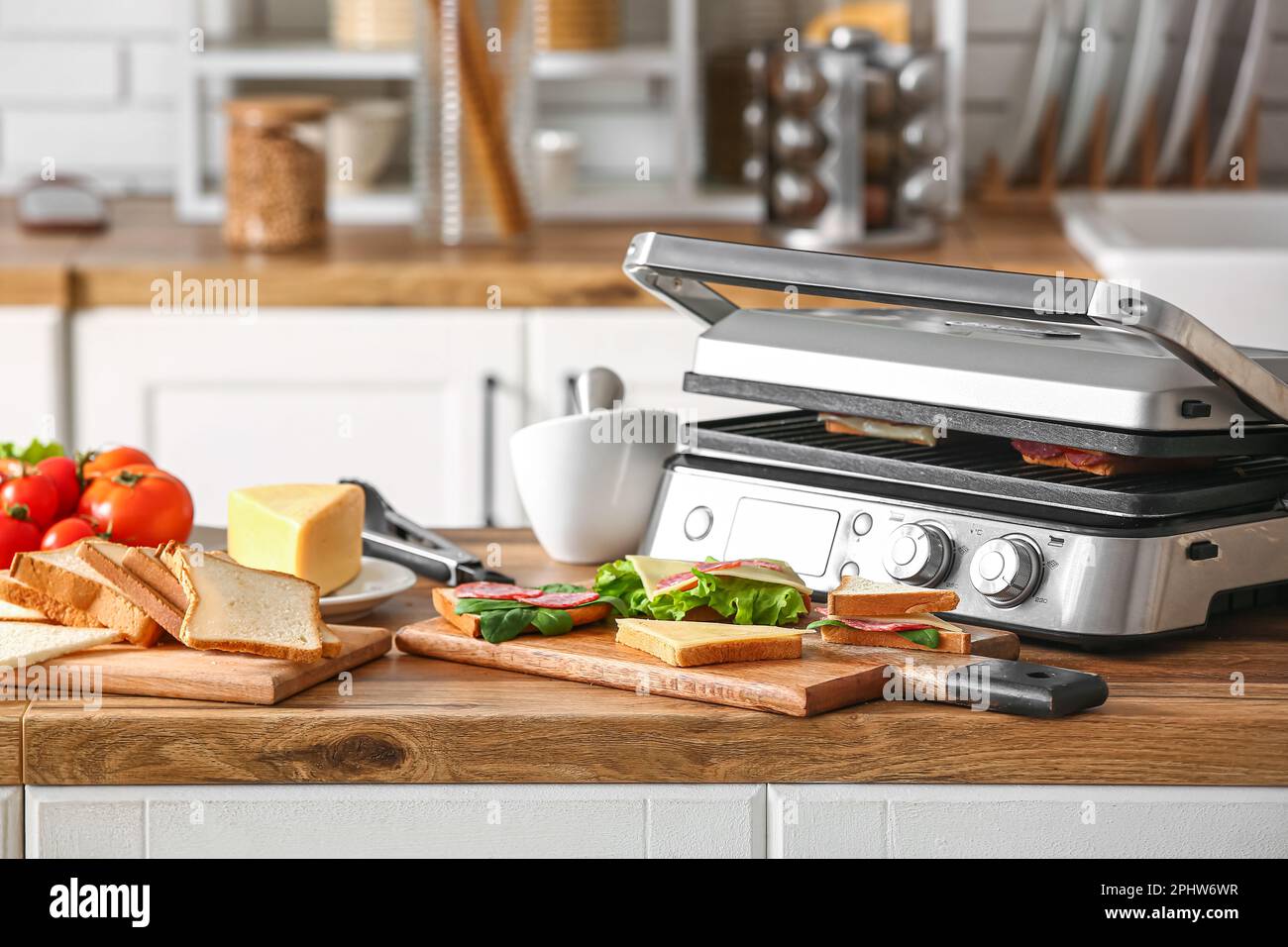 Modern electric grill with sandwiches on kitchen counter Stock Photo ...