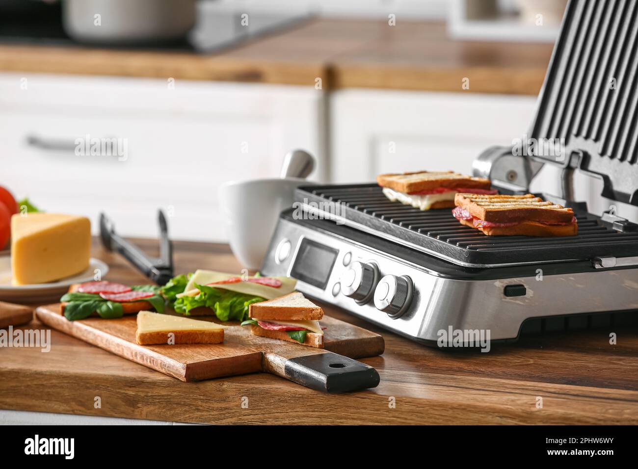 Modern electric grill with sandwiches on kitchen counter Stock Photo ...