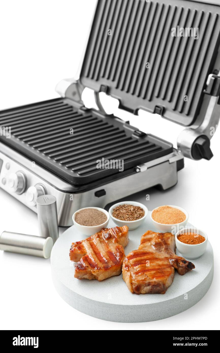 Modern electric grill, board with delicious steak and spices isolated ...