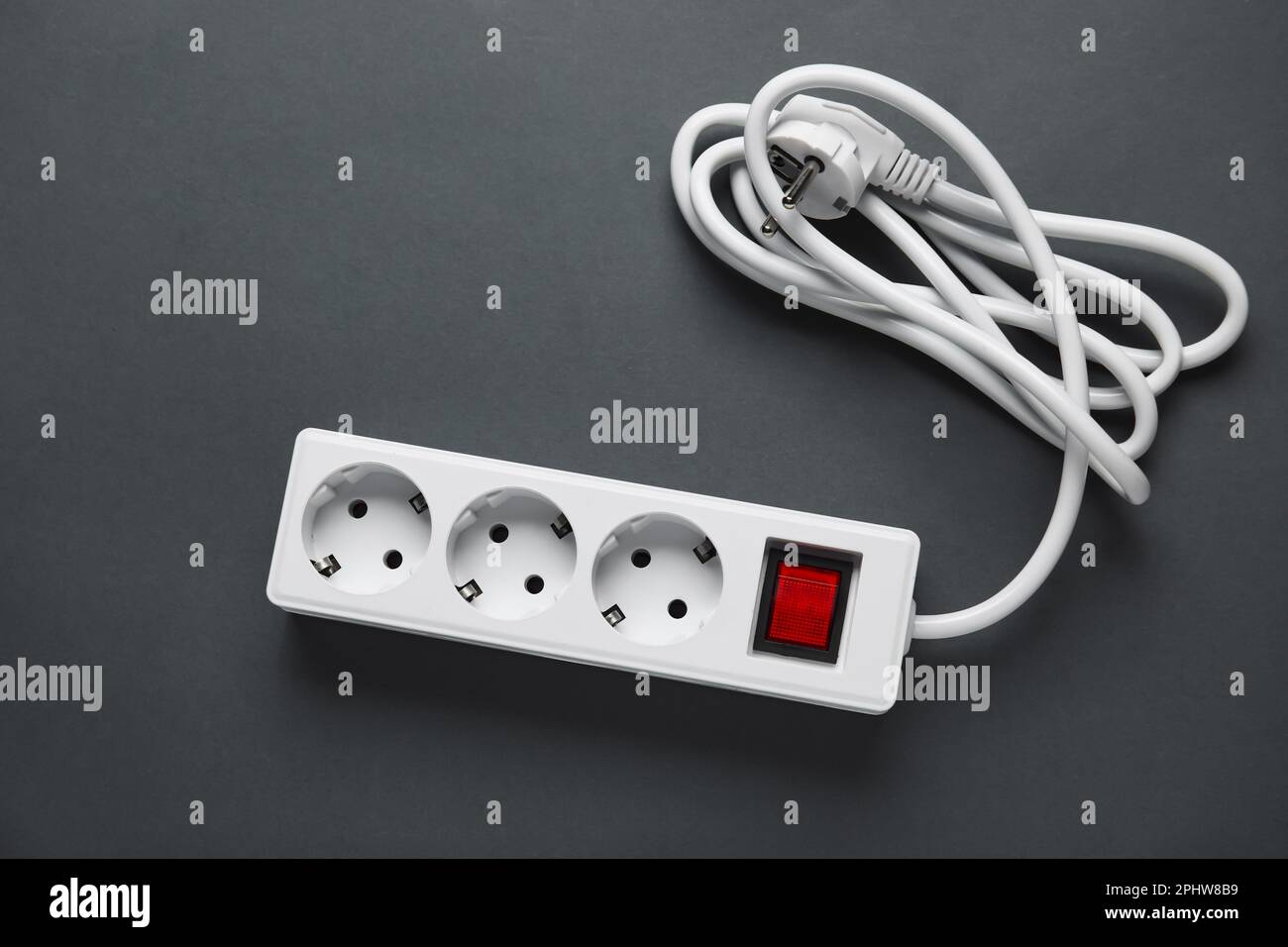 Electric extension cord on grey background Stock Photo - Alamy