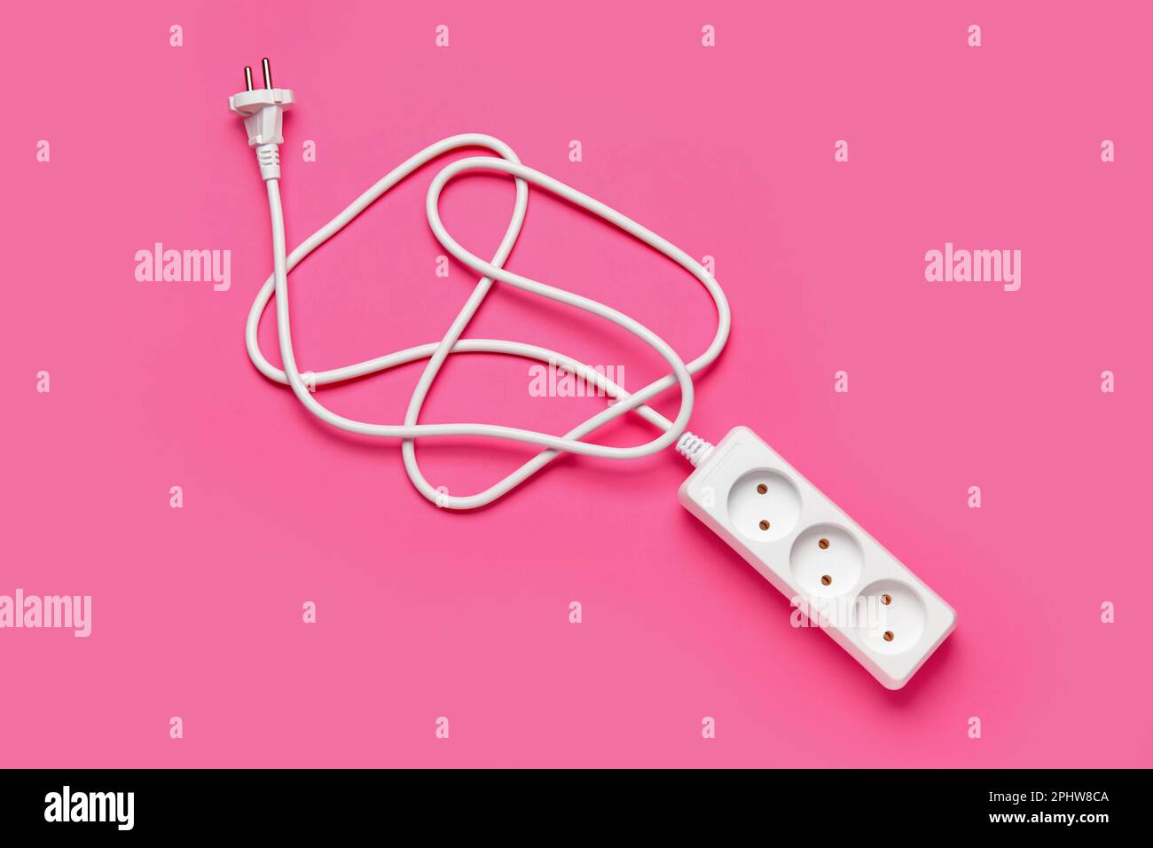 Electric extension cord on pink background Stock Photo - Alamy