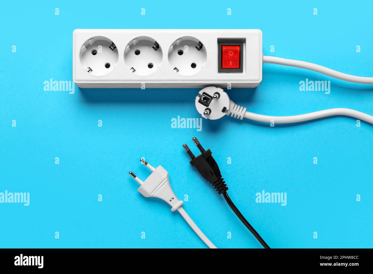 Electric extension cord and plugs on blue background Stock Photo - Alamy