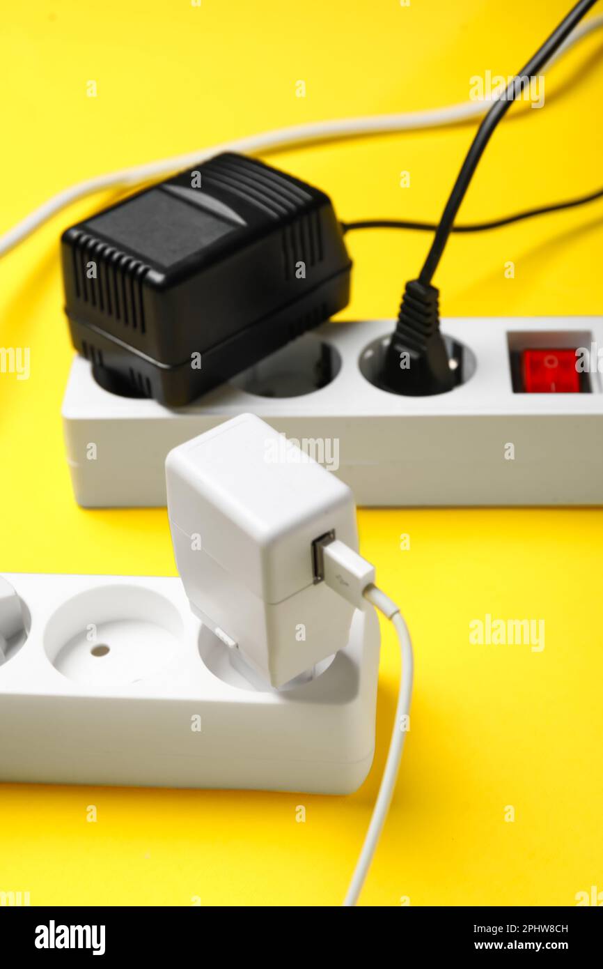Electric extension cords with plugs on yellow background Stock Photo ...