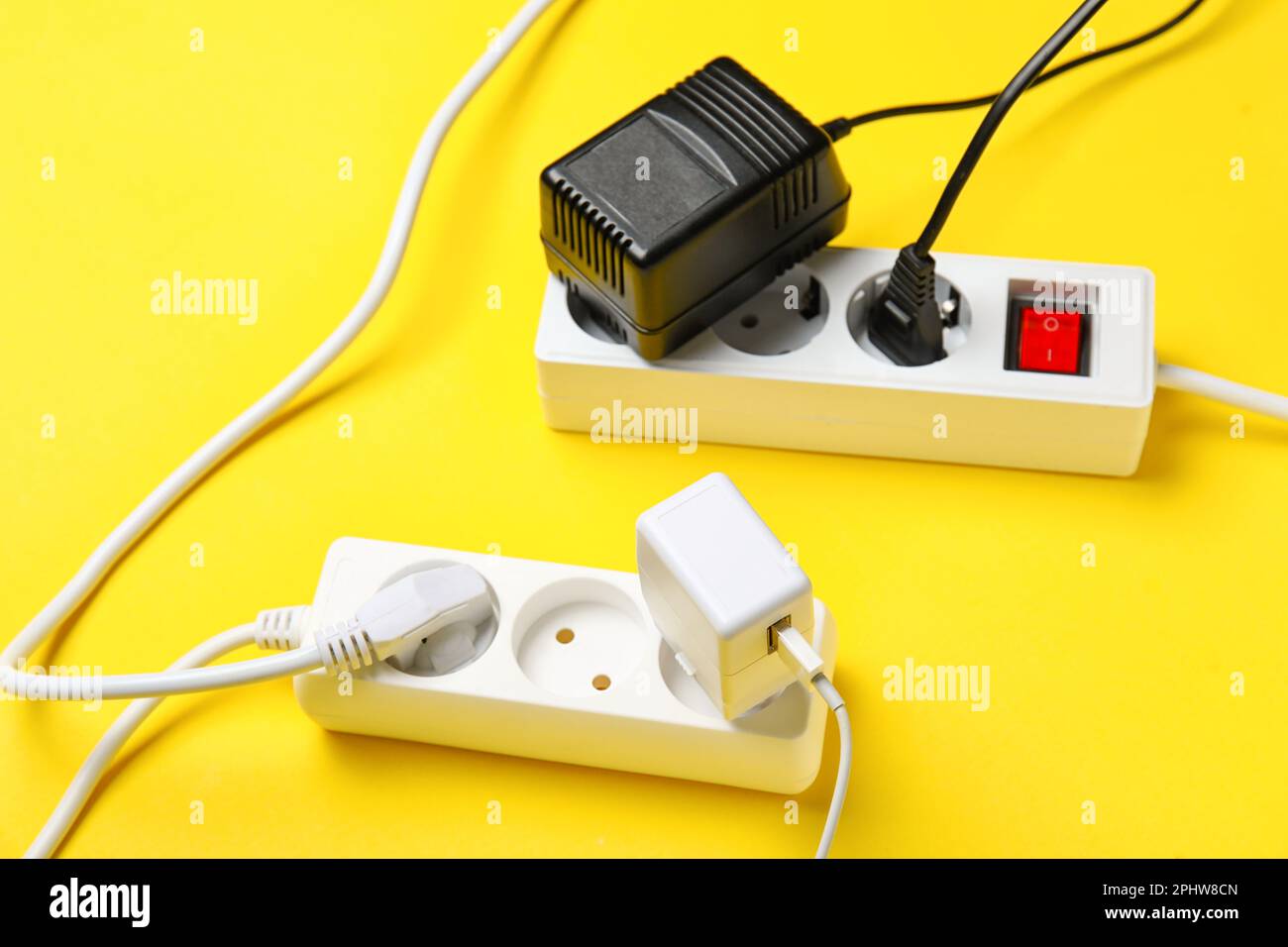 Electric extension cords with plugs on yellow background Stock Photo ...