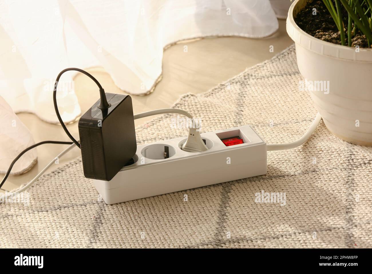 Electric extension cord with plugs on carpet Stock Photo - Alamy