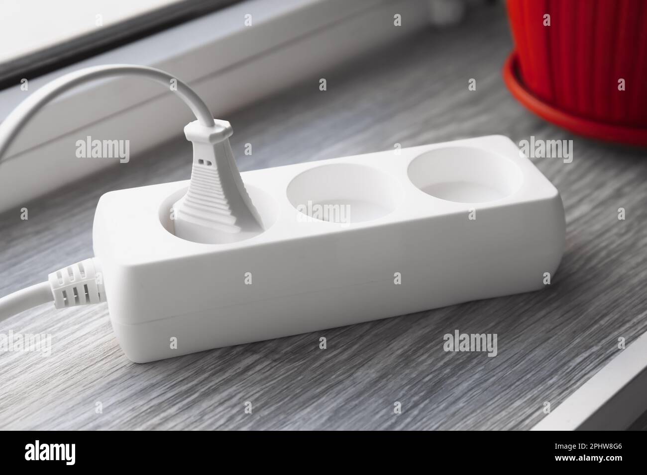 Electric extension cord with plugs on wooden windowsill Stock Photo - Alamy