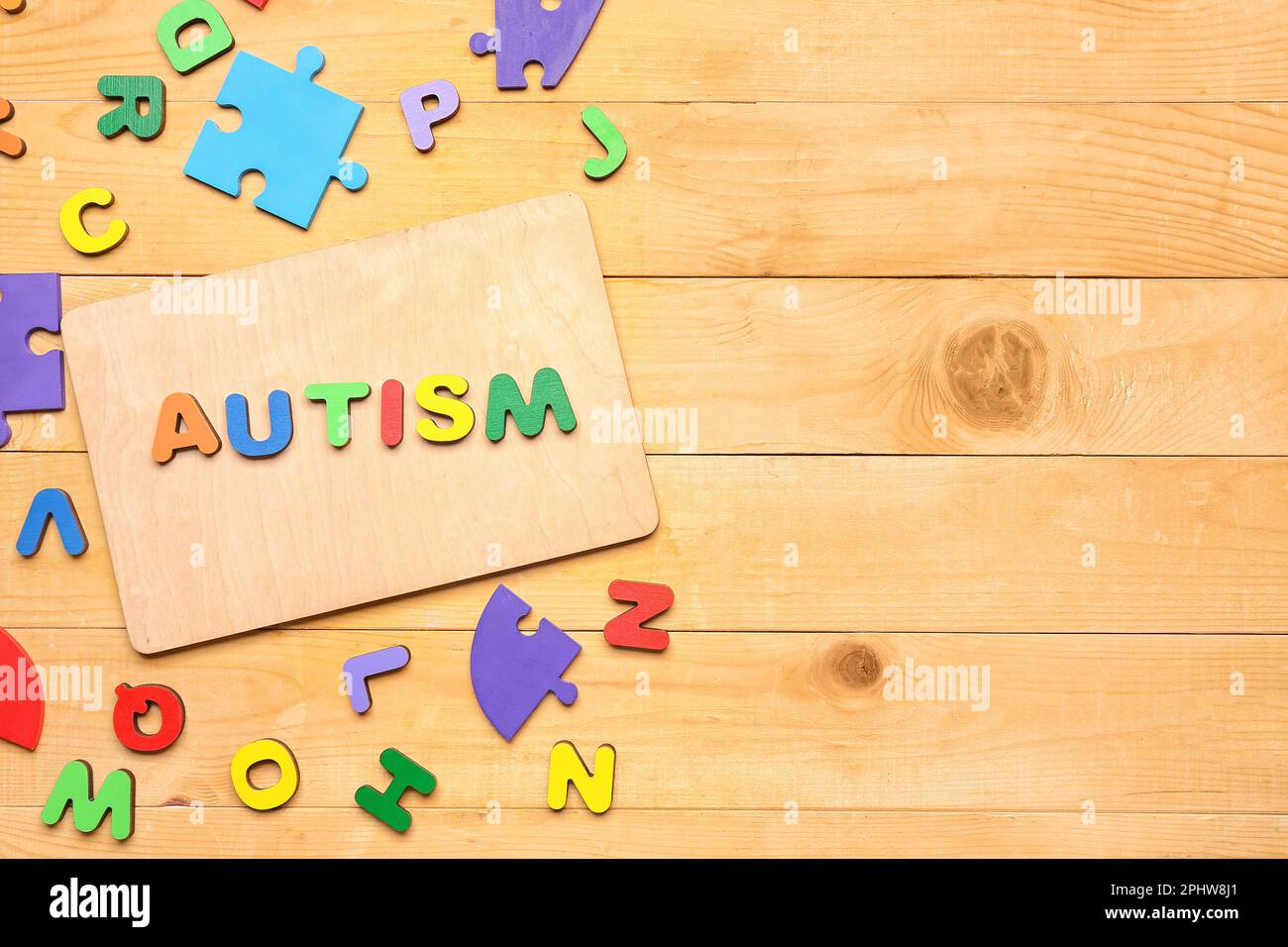 Word AUTISM with letters and puzzle pieces on wooden background Stock ...
