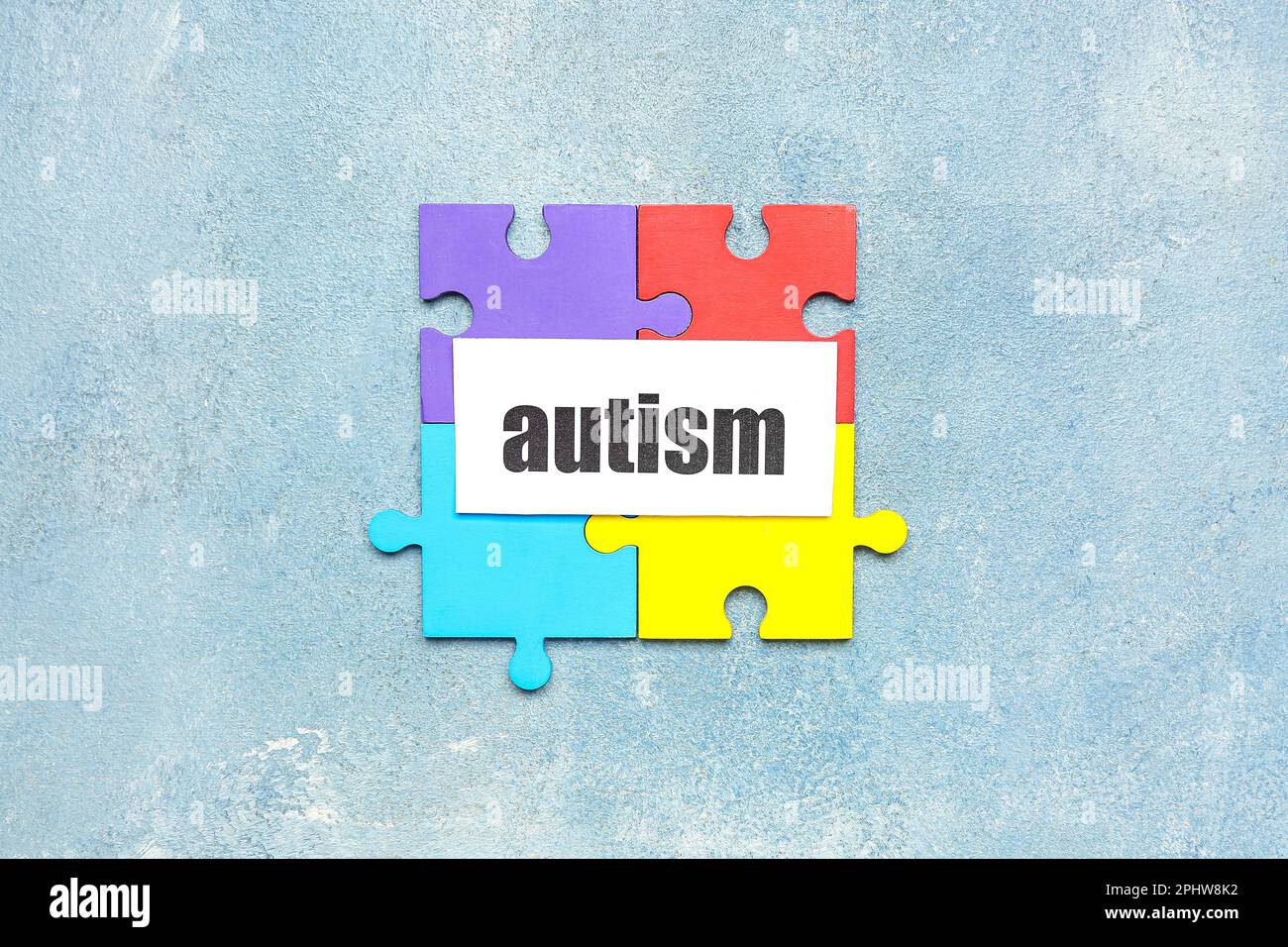 Word AUTISM with puzzle pieces on grunge background Stock Photo - Alamy