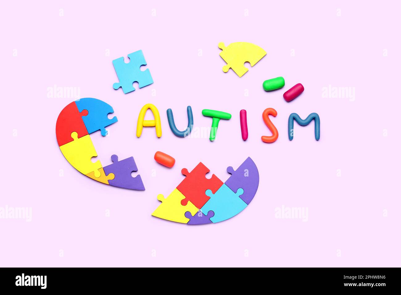 Word AUTISM with puzzle pieces on lilac background Stock Photo - Alamy