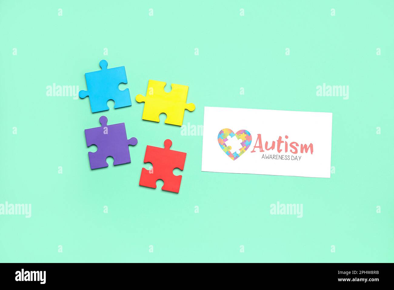 Paper with text AUTISM AWARENESS DAY and puzzle pieces on green ...