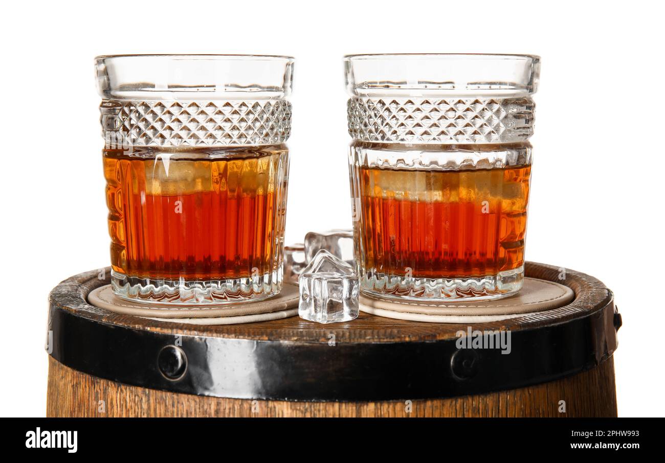 Glasses of cold rum on wooden barrel against white background Stock ...