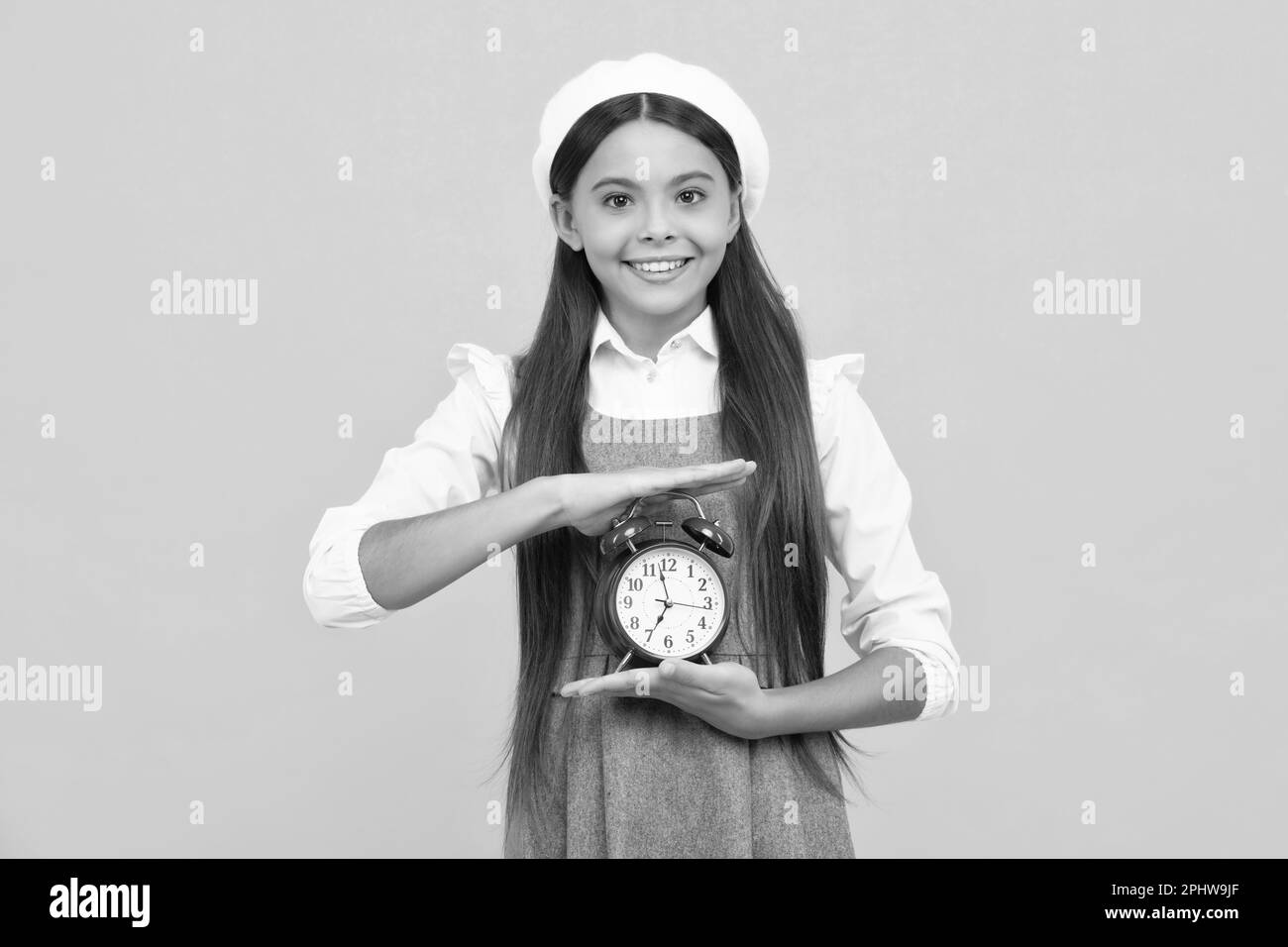 Portrait of teenage girl with clock alrm, time and deadline. Studio ...