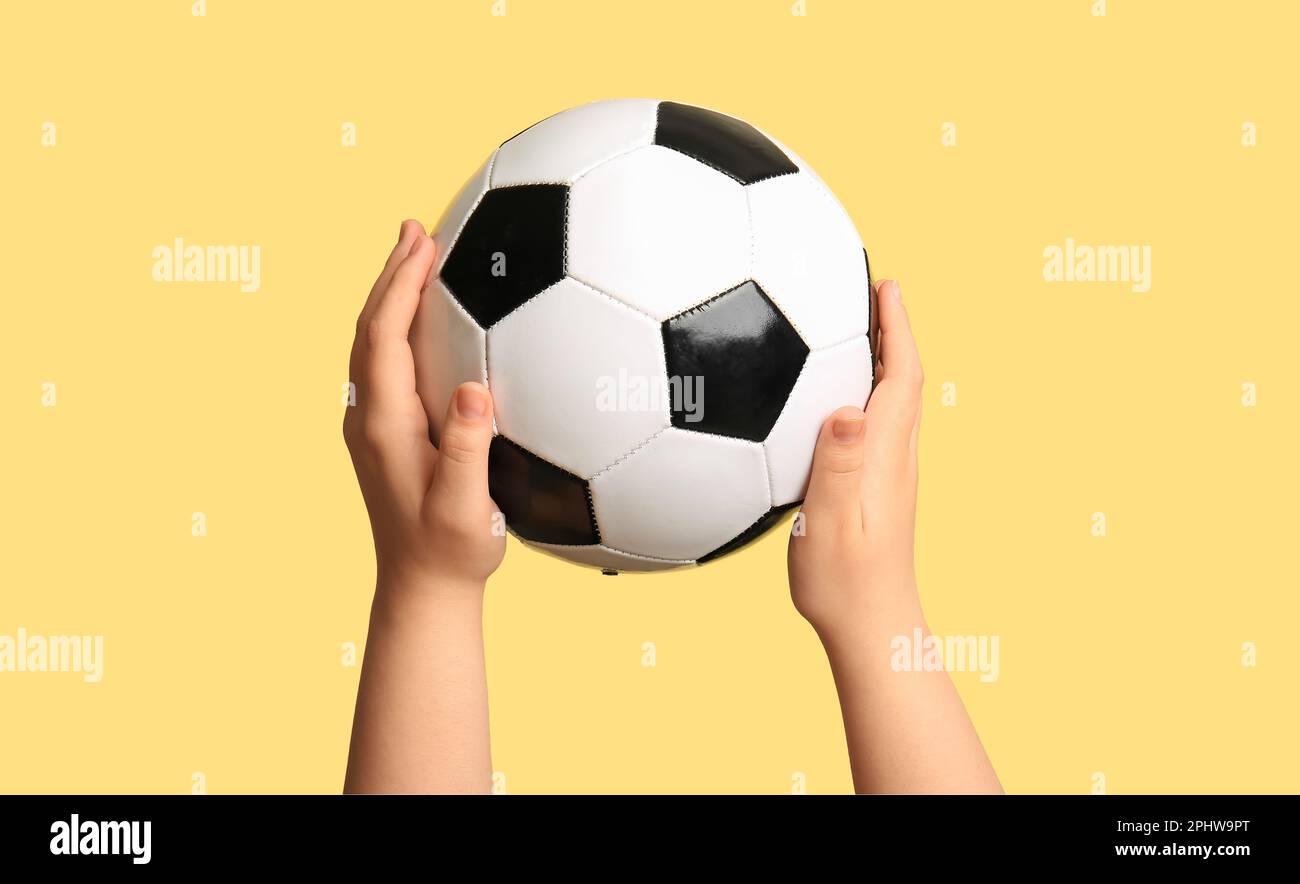 Child's hands with soccer ball on beige background Stock Photo - Alamy