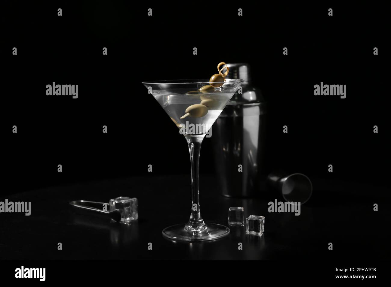 Glass of tasty martini, ice cubes and olives on black background Stock ...