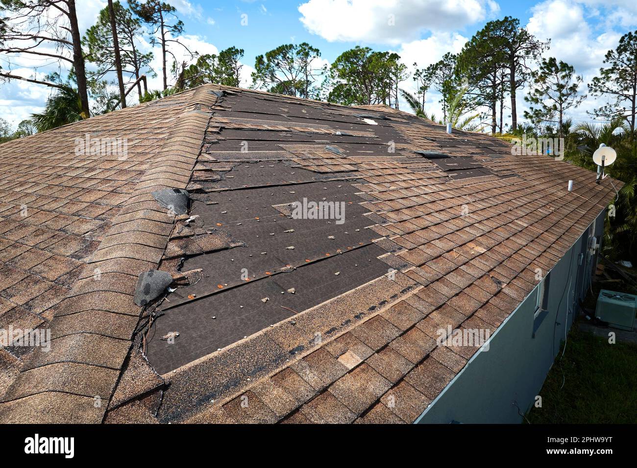 Damaged house roof with missing shingles after hurricane Ian in Florida ...