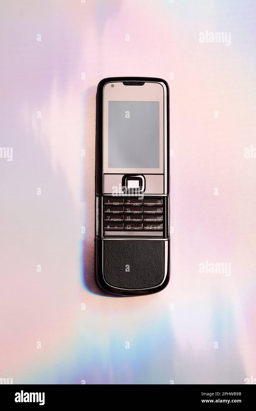 Old mobile phone on holographic background. retro, vintage and ...