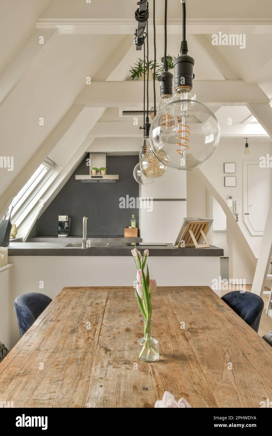 a wooden table and chairs in a room with an attic style ceiling above ...