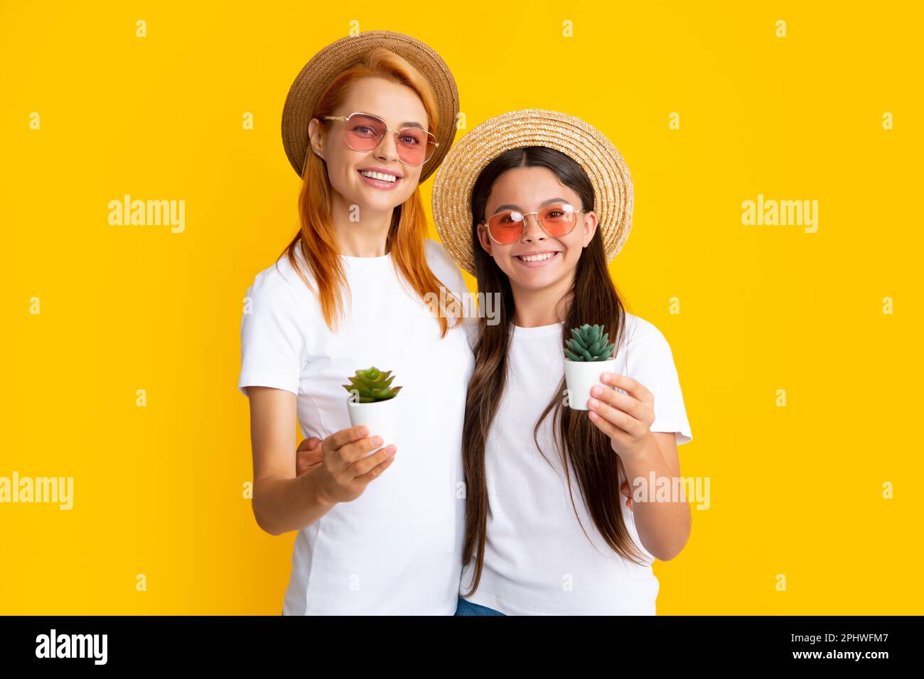 Mother and daughter teenager child, gardening planting plant in pot ...