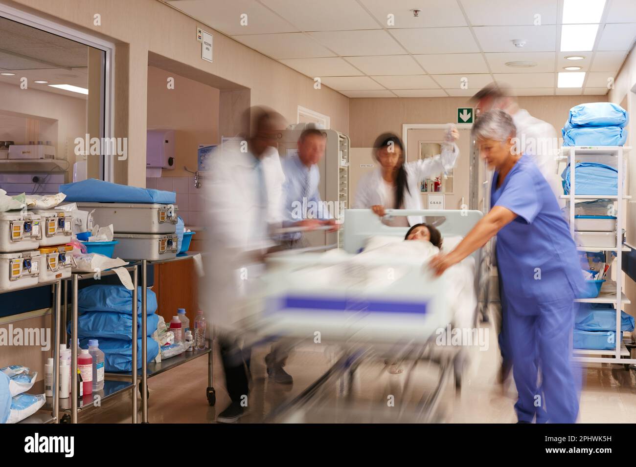 Racing to save their patient. a medical teamrushing a gurney through a ...