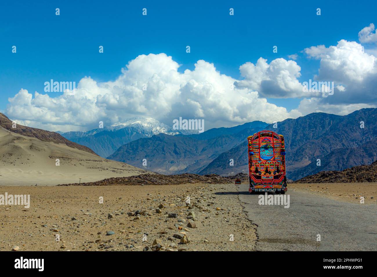 landscape of snow mountains and road with colorful trucks , beautiful ...