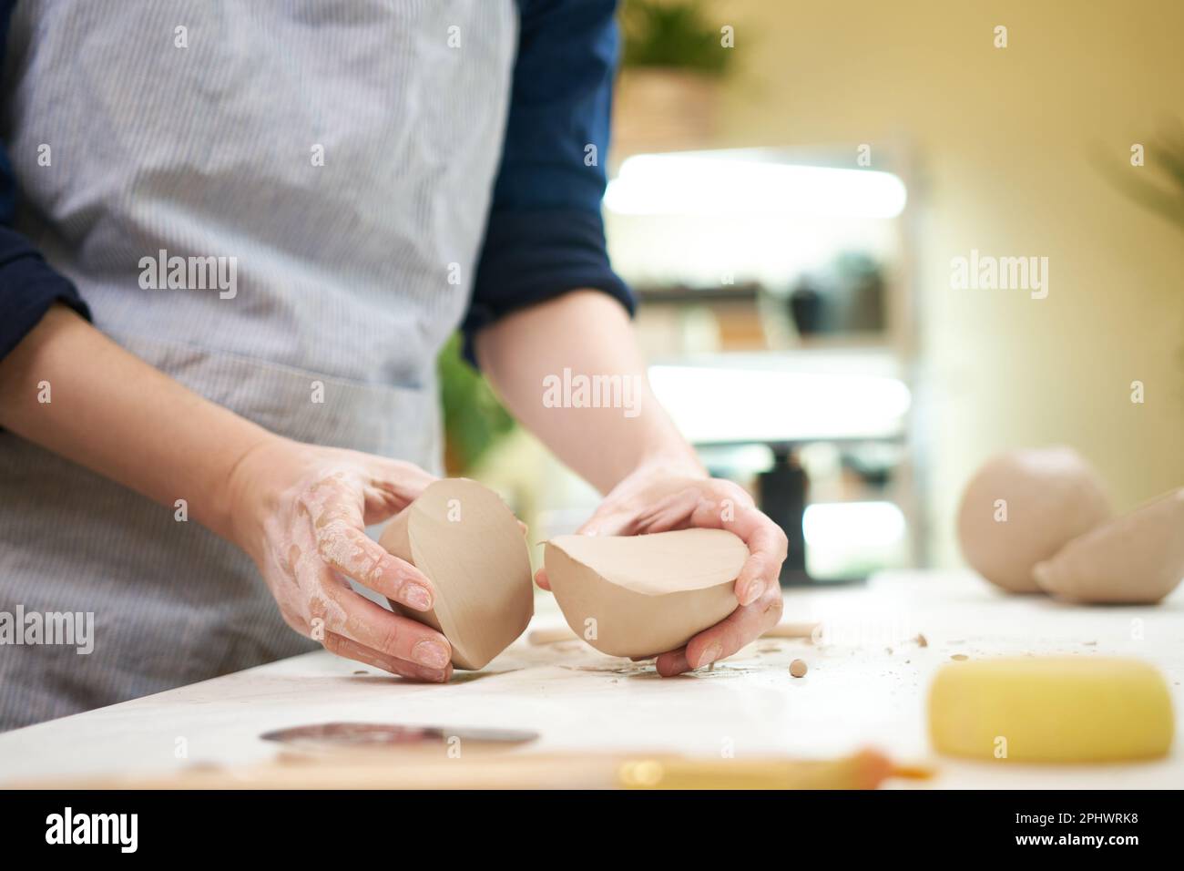 Female hands holding sliced clay ball for making ceramic goods in art ...
