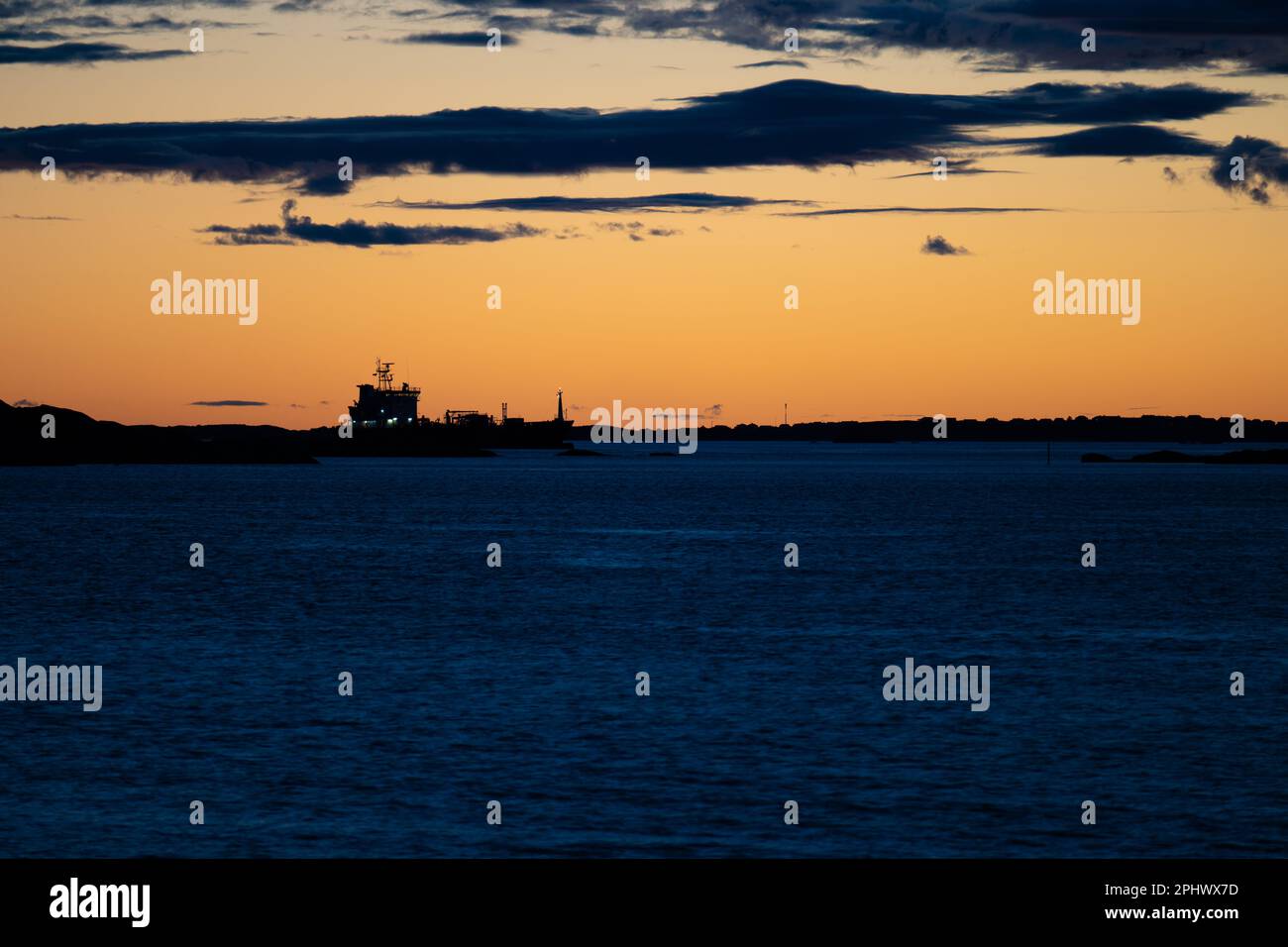 Silhouette of tanker ships in sunset light Stock Photo - Alamy