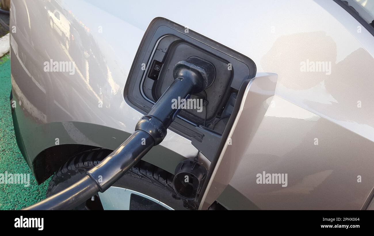 Power supply plugged into an electric car charging station Stock Photo ...