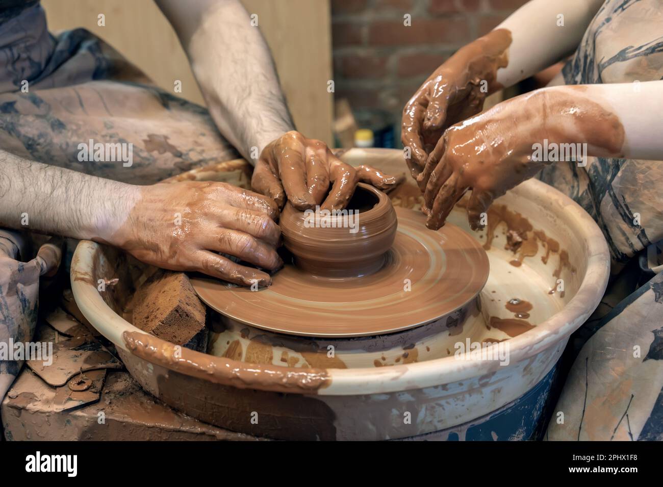 hands of a master potter and a child making dishes. A lesson in a ...
