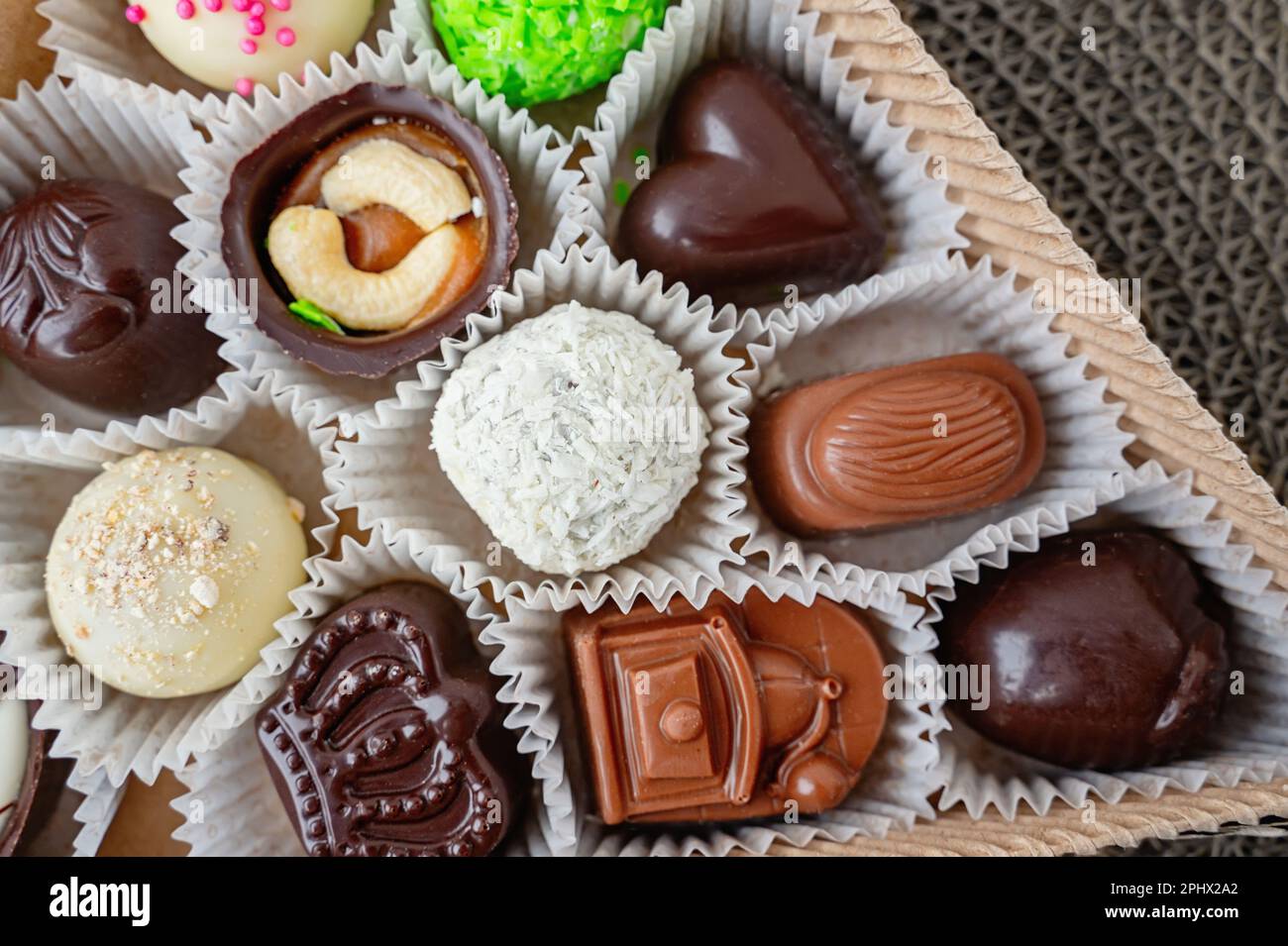 Assorted handmade chocolates. Candy in a triangular box Stock Photo - Alamy