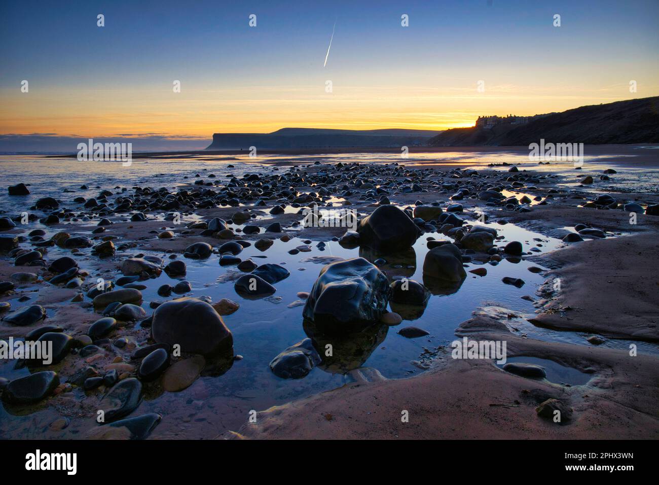 Tides out golden hour plane trail hi-res stock photography and images ...