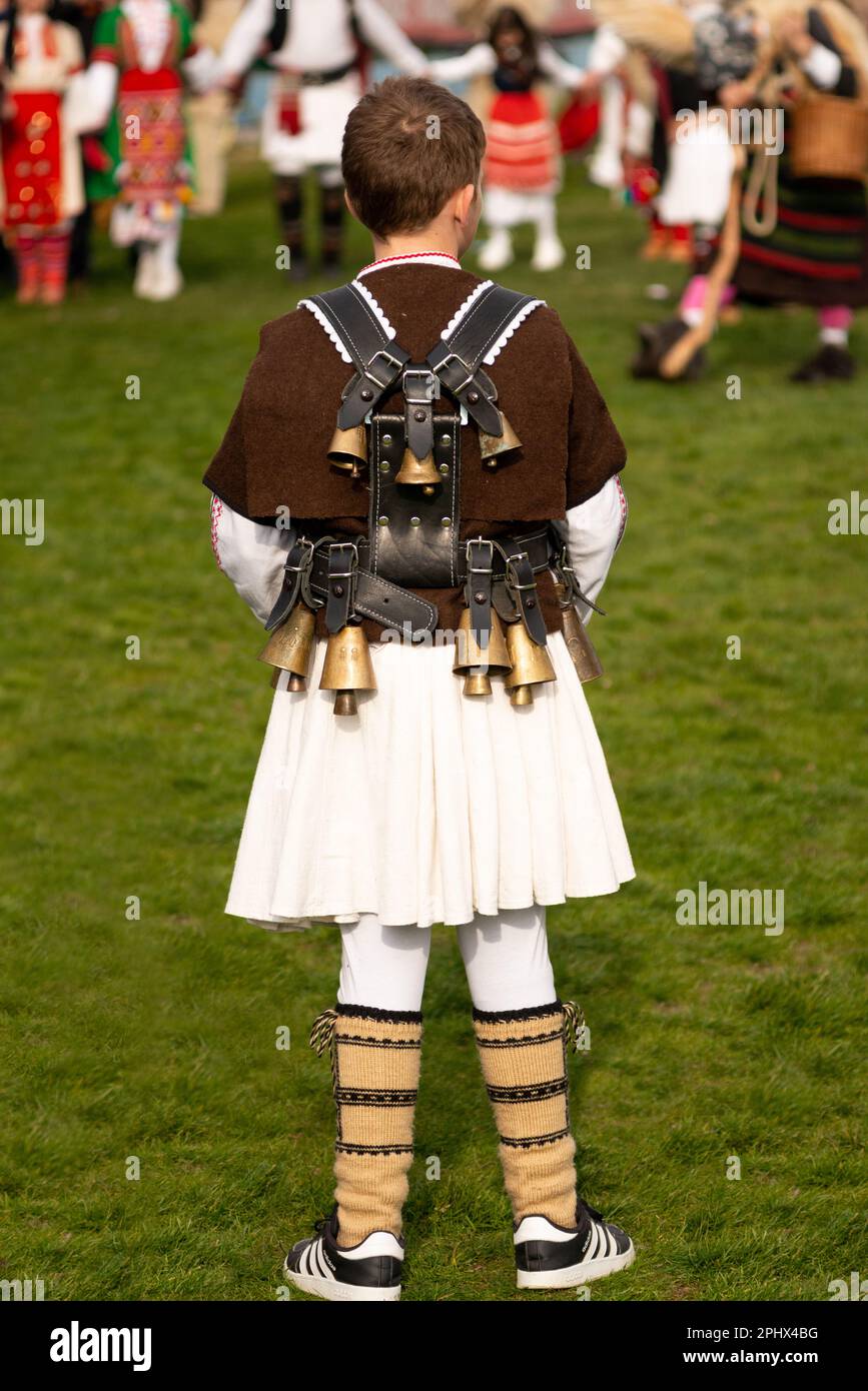 Rear view of young dancer boy in intricate costume and bells ...