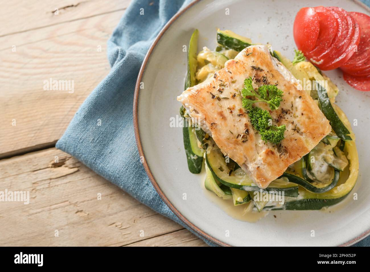 Roasted wild salmon fillet with parsley garnish on creamy zucchini ...