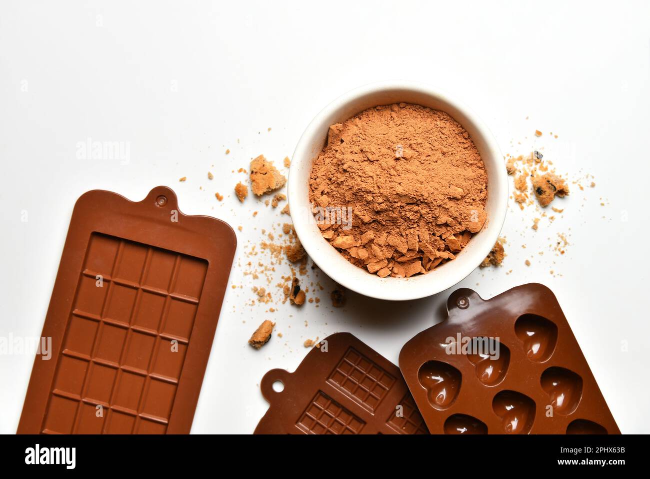 Cocoa in a bowl and molds for making chocolate. Cooking homemade ...