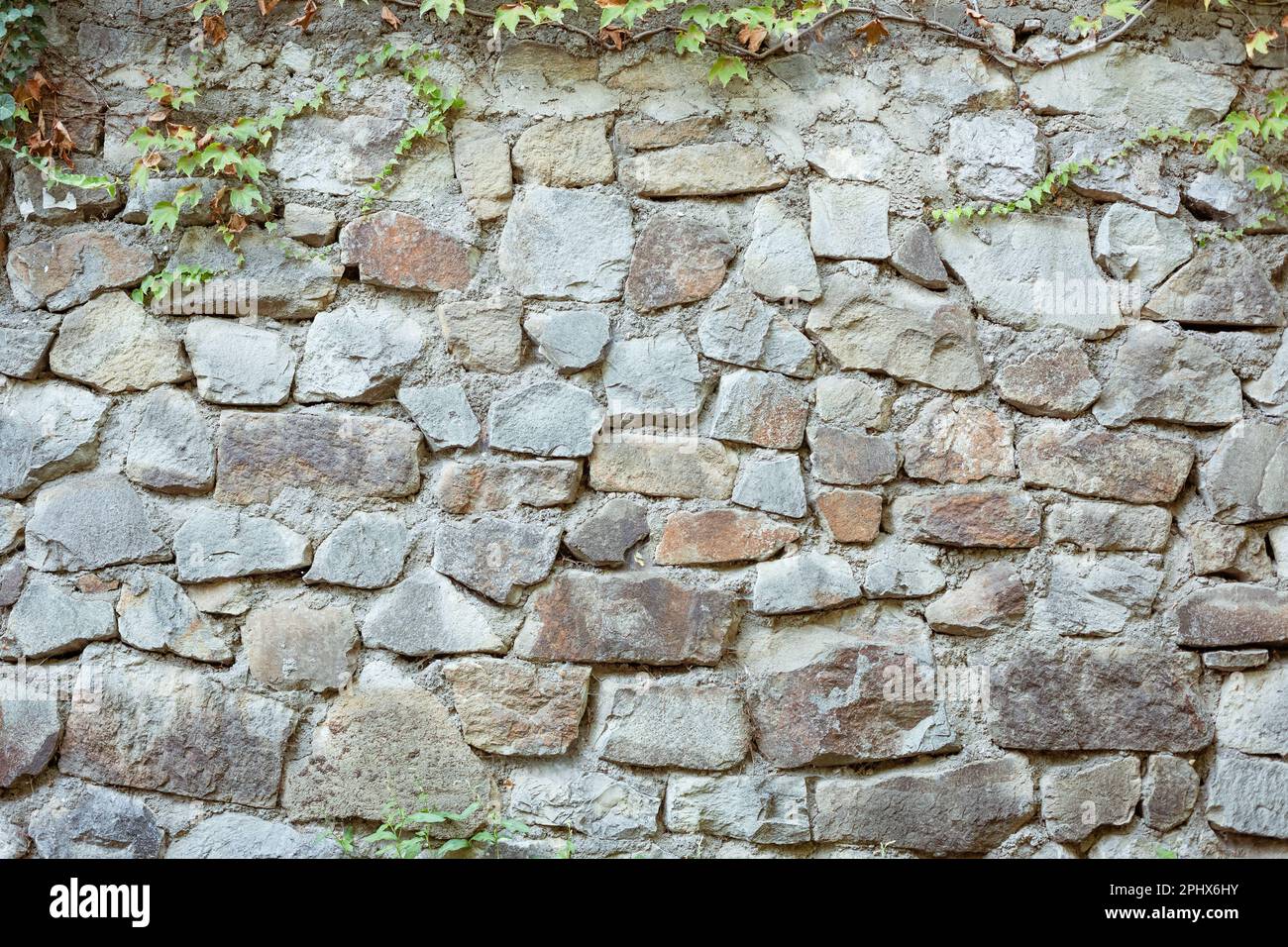 Textured background irregular natural stone wall made of different ...