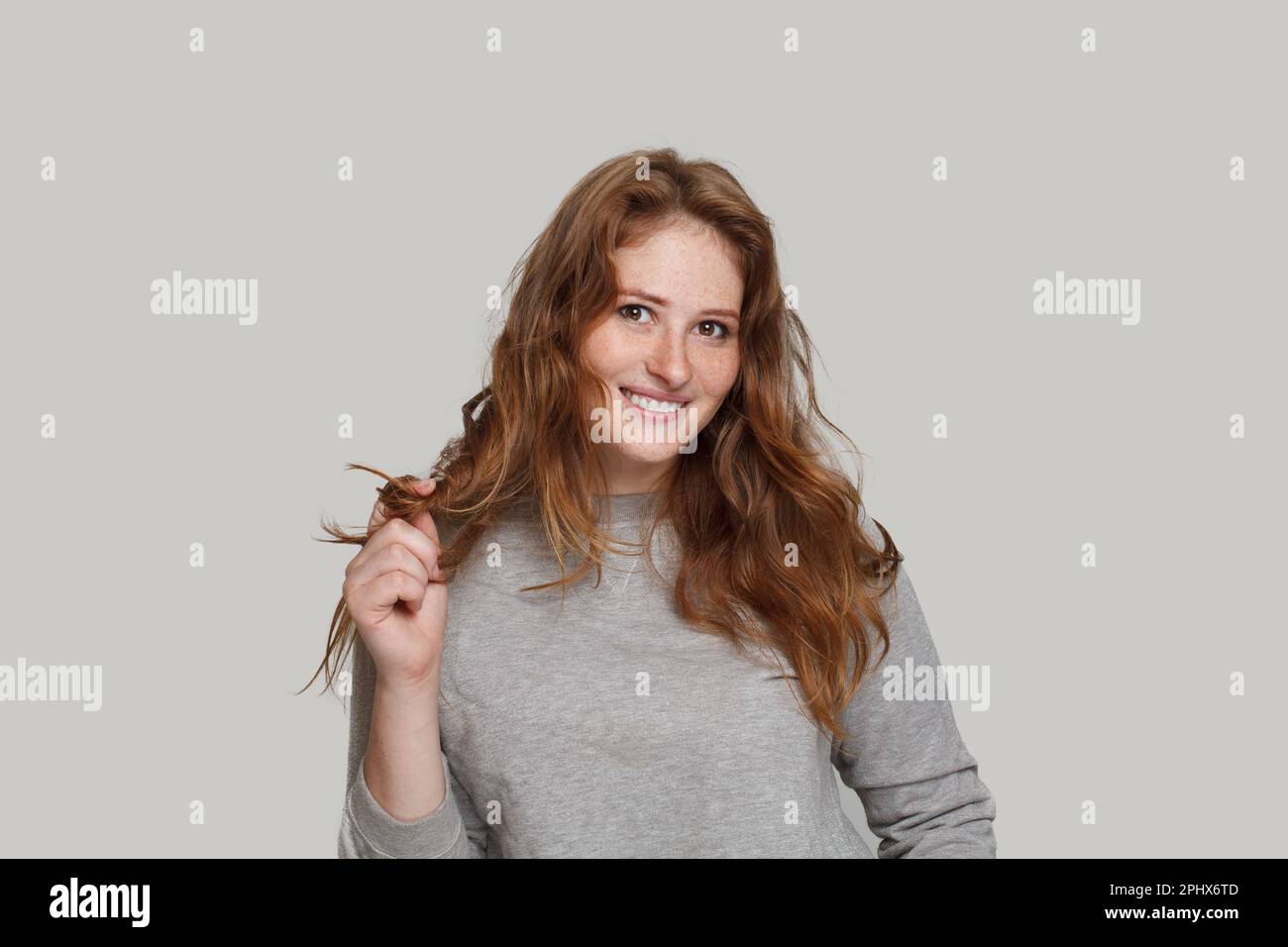 Portrait of lovely healthy beauty redhead woman touching her long ...