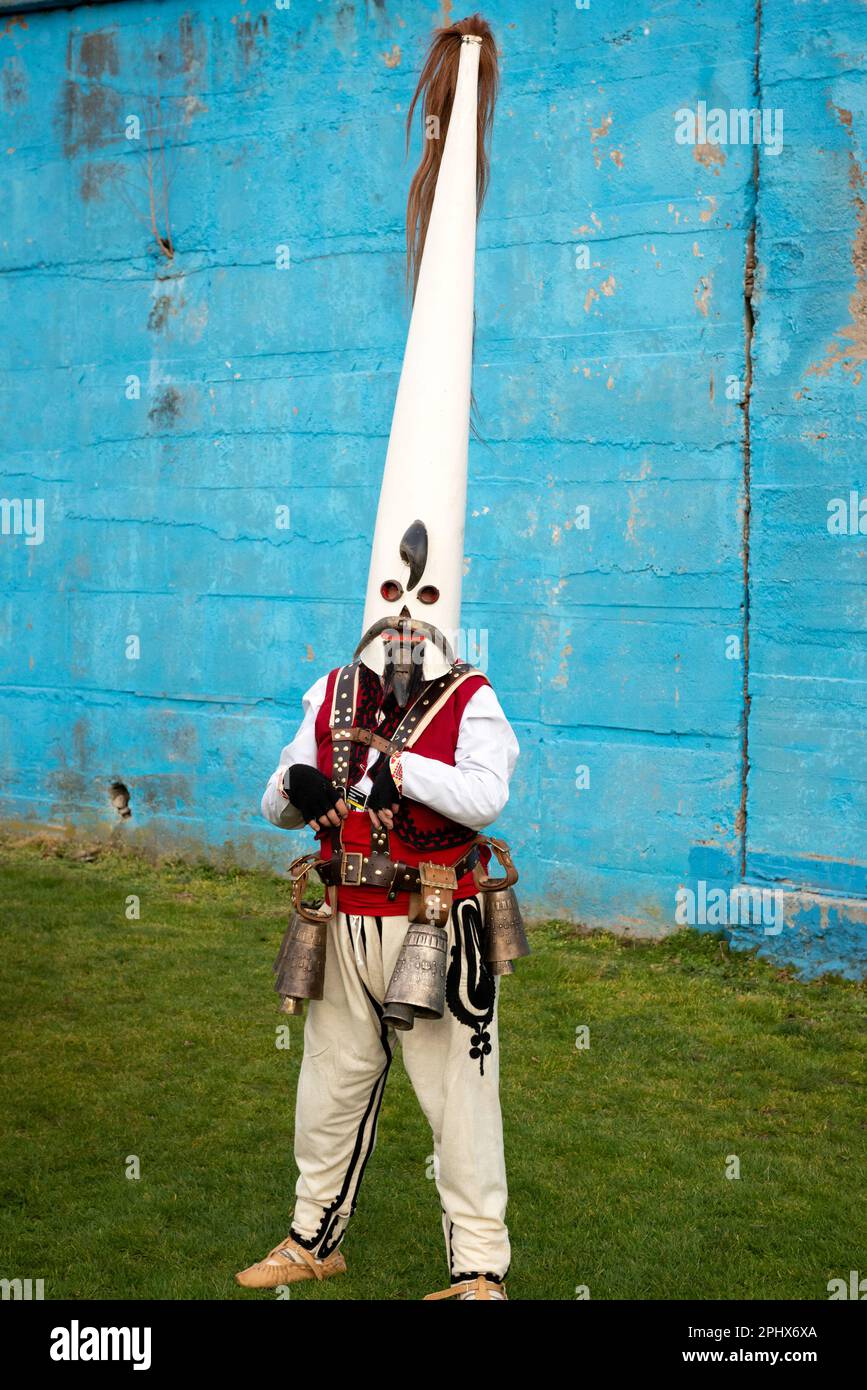 Kukeri dancer in white outfit with distinctive tall conical mask at the ...