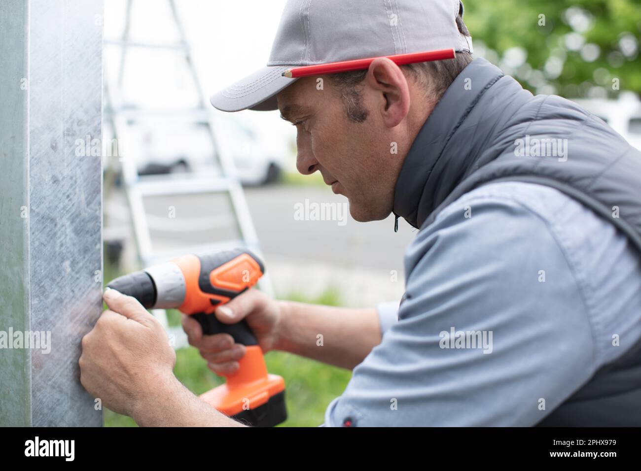 workman in helmet holds perforator Stock Photo - Alamy