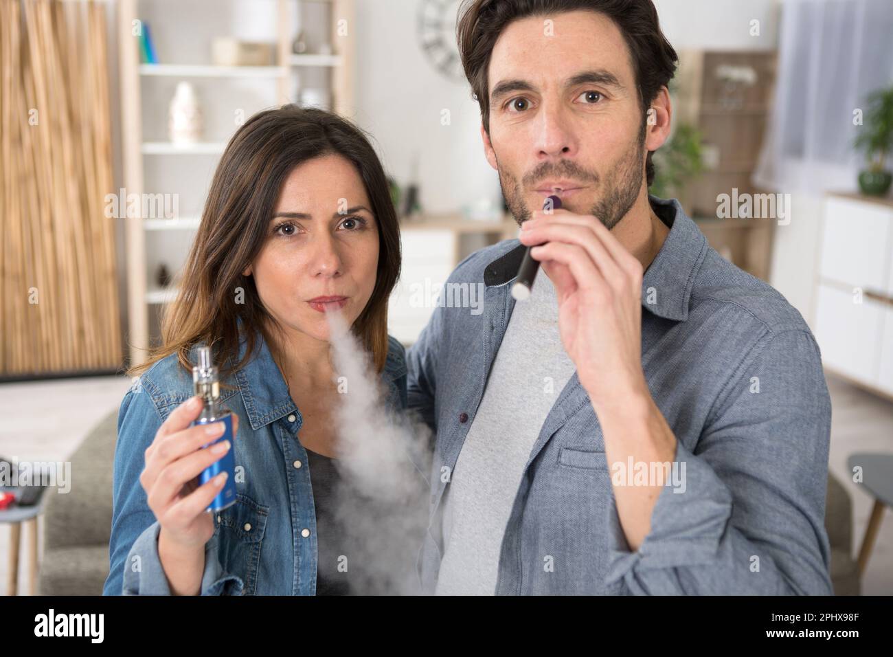 portrait of couple smoking electronic cigarettes Stock Photo - Alamy