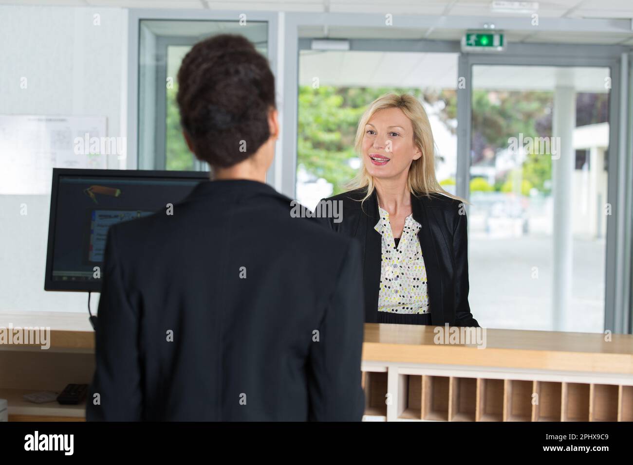 guest asking questions from the receptionist Stock Photo - Alamy